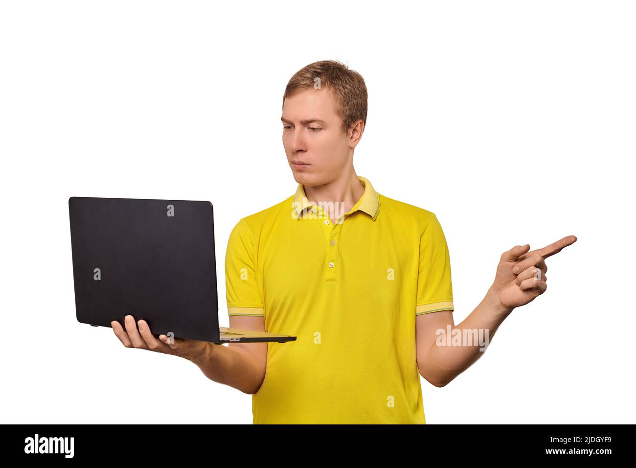 Puzzled young man in yellow T-short holding laptop in black case and ...