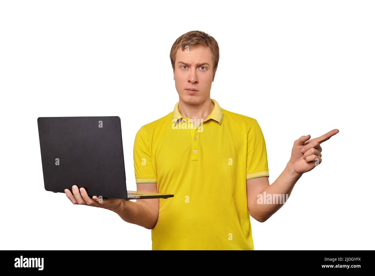 Puzzled young man in yellow T-short holding laptop in black case and ...