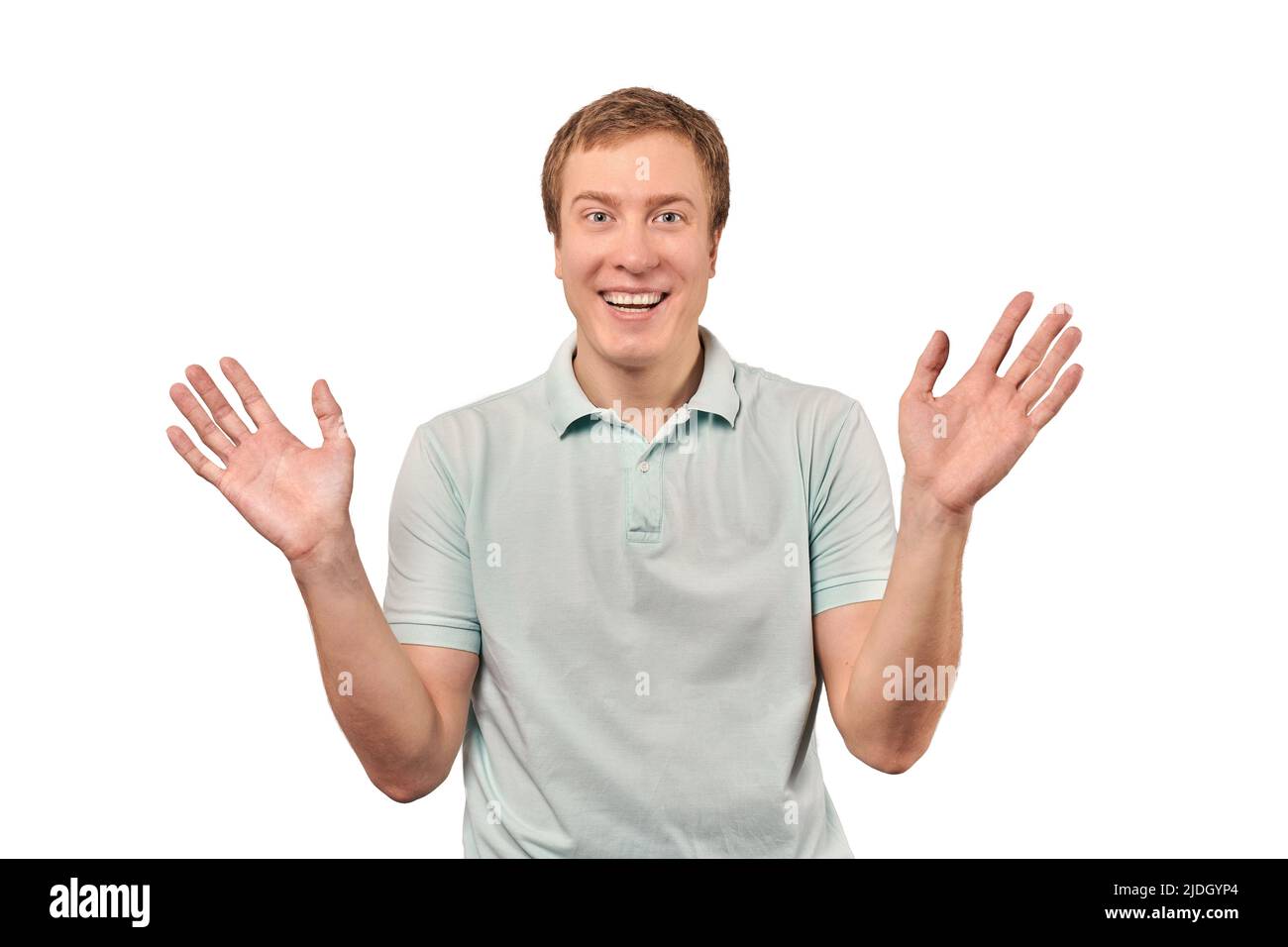 Funny smiling guy in mint T-shirt showing palms of hands, unexpected ...
