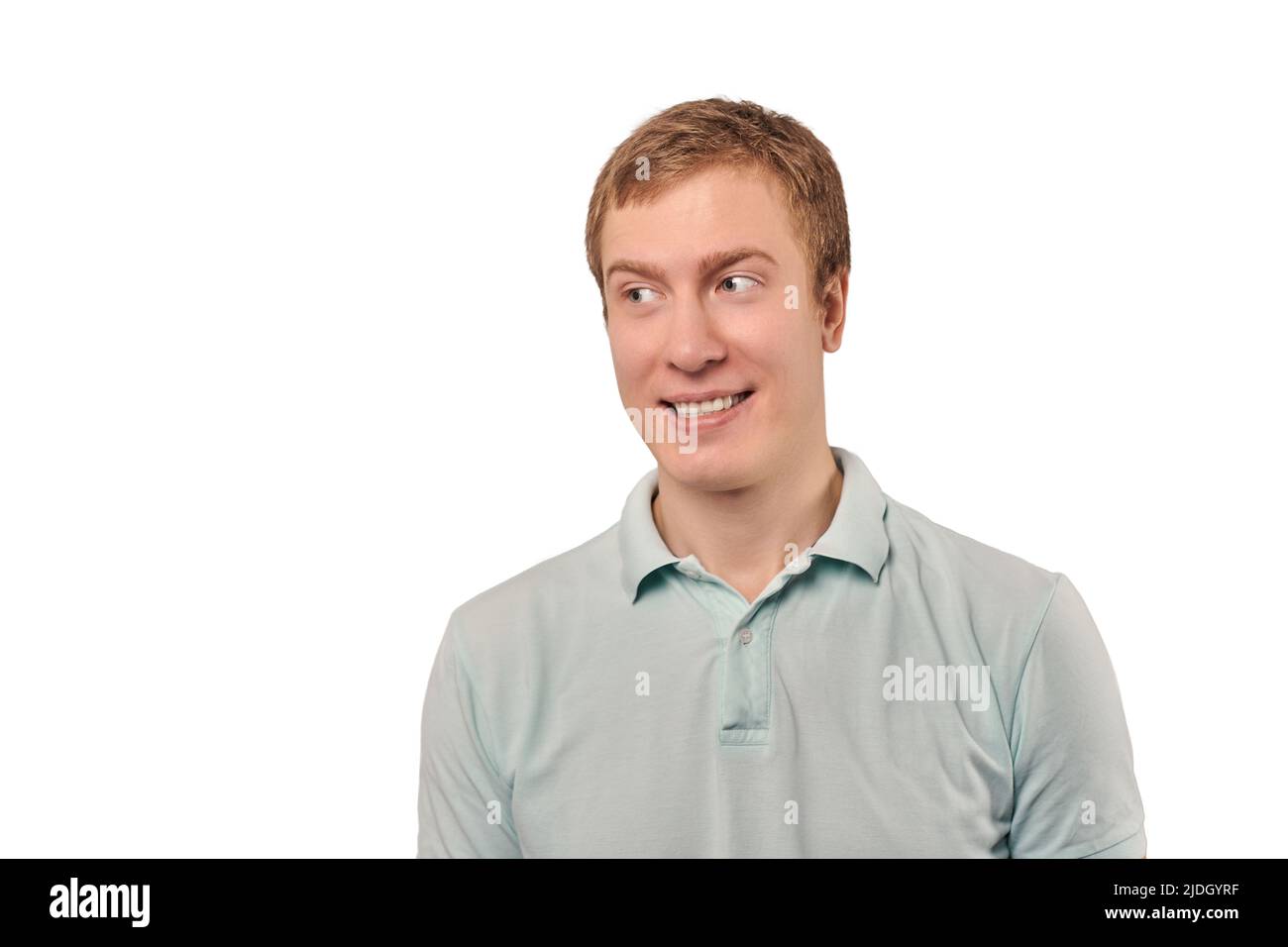 Portrait of funny young guy looking left in light grey T-shirt isolated ...
