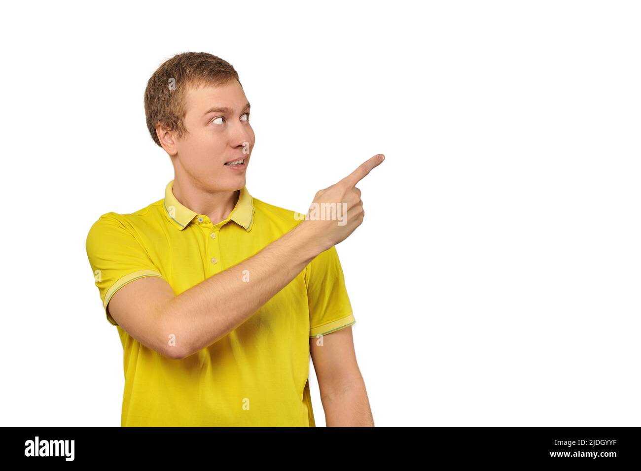 Surprised young guy with funny face in bright yellow T-shirt pointing ...