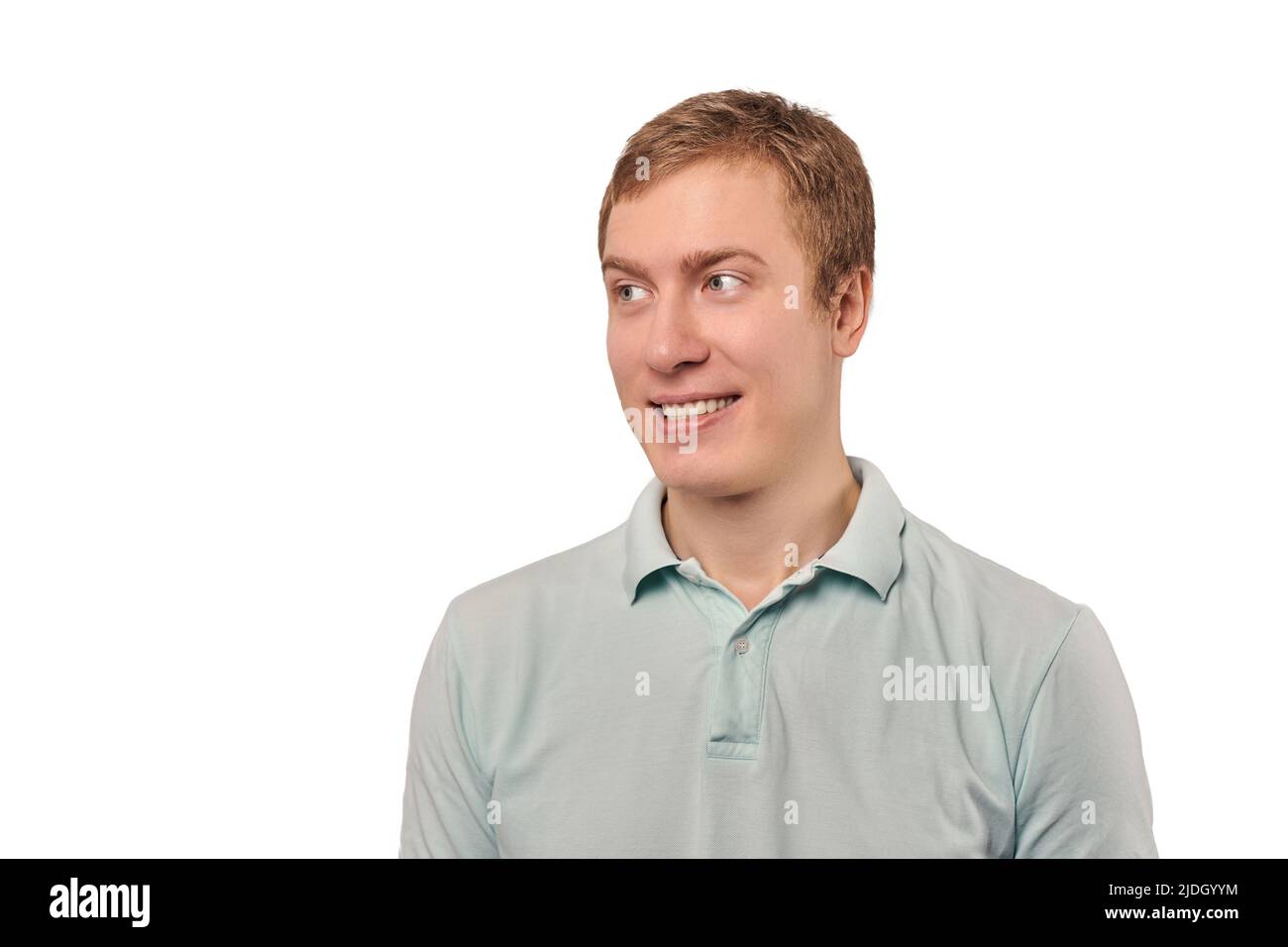 Portrait of funny young guy looking left in light grey T-shirt isolated ...