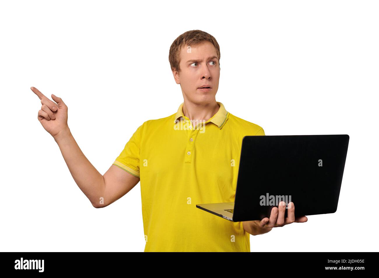 Puzzled young man in yellow T-short holding laptop in black case and ...