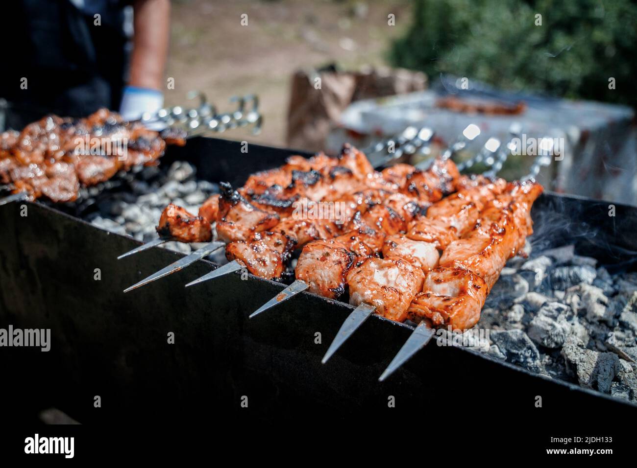 Close-up on shish kebab on skewers are fried on a outdoor grill Stock ...