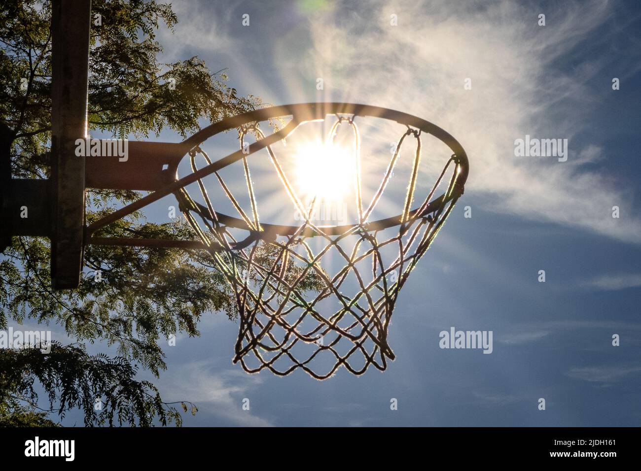 Shot of the sun setting into a basketball hoop Stock Photo - Alamy