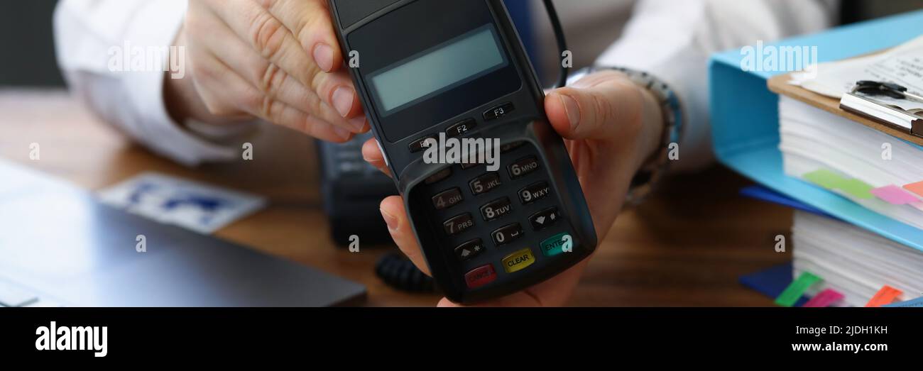 Man holding modern credit card reader machine for cashless payment ...