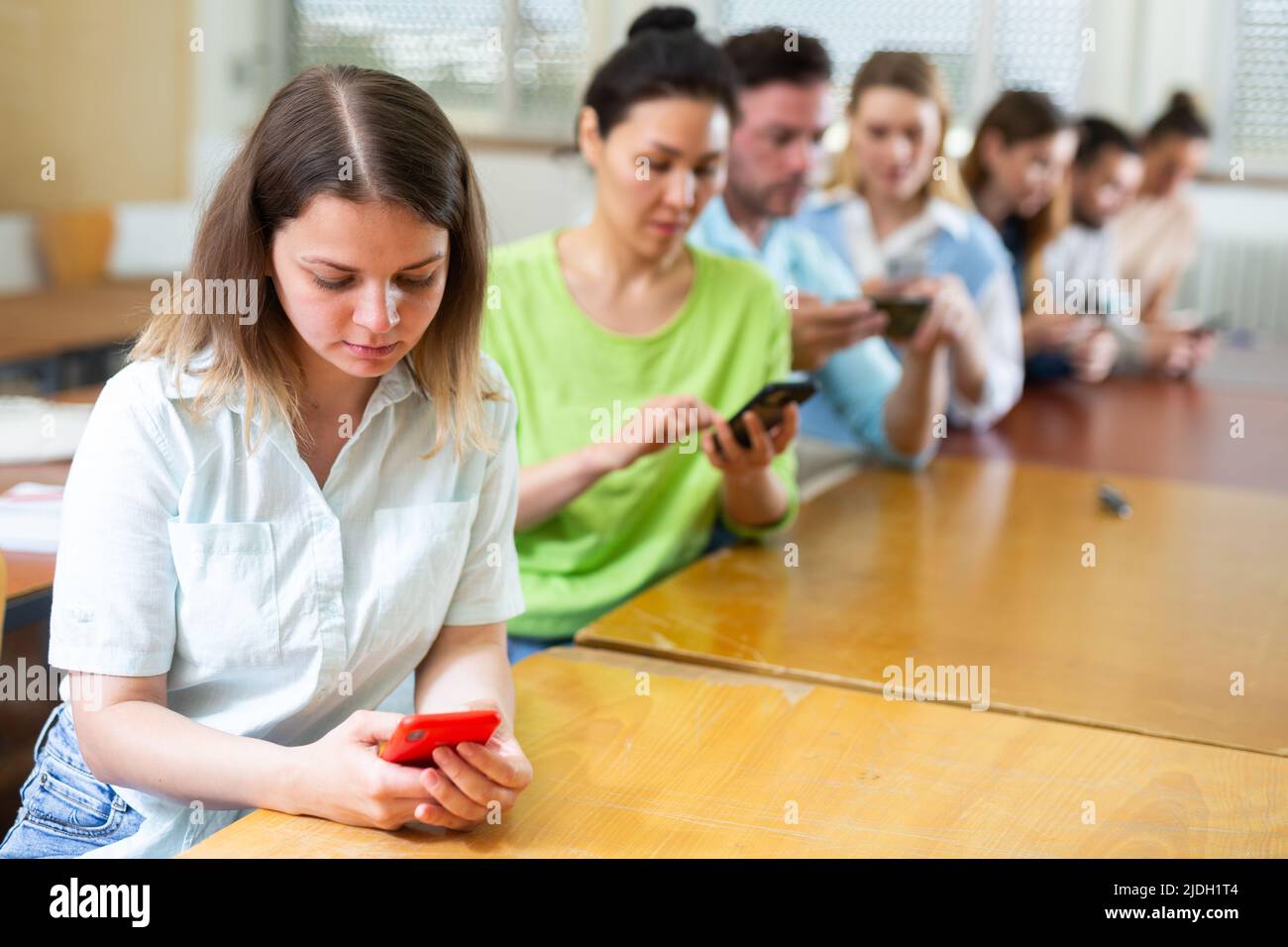 Portrait of students using mobile phones during lesson Stock Photo - Alamy