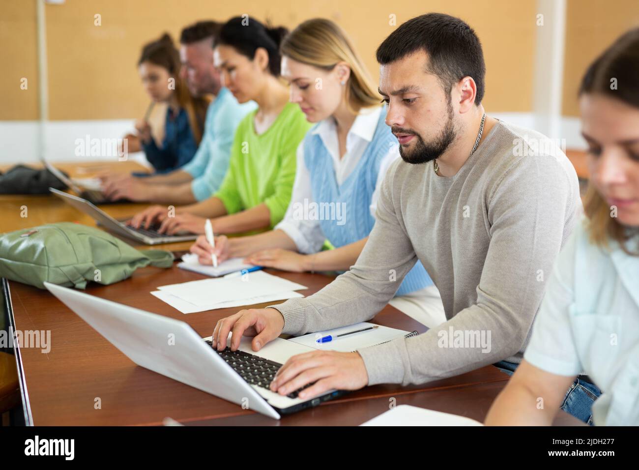 Adult students listening task for exam in classroom Stock Photo - Alamy