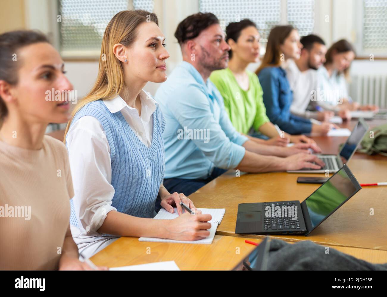 Group of students attentively listening to lecture in university ...
