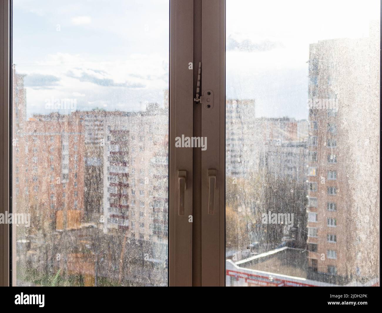 cityscape view through dirty window glass in multi-storey residential ...