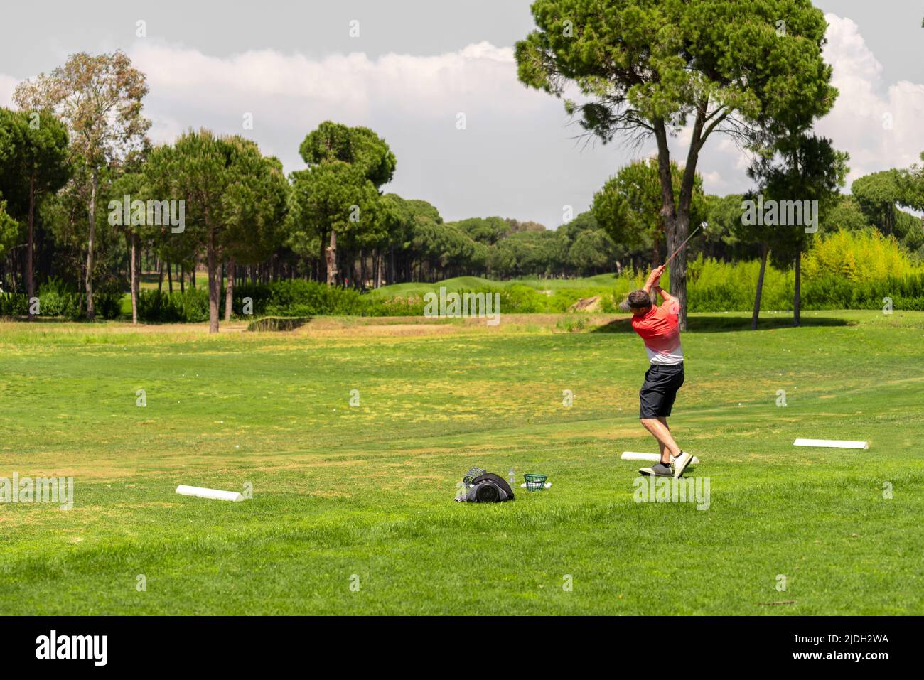 Golfer training his swing on golf driving range Stock Photo - Alamy