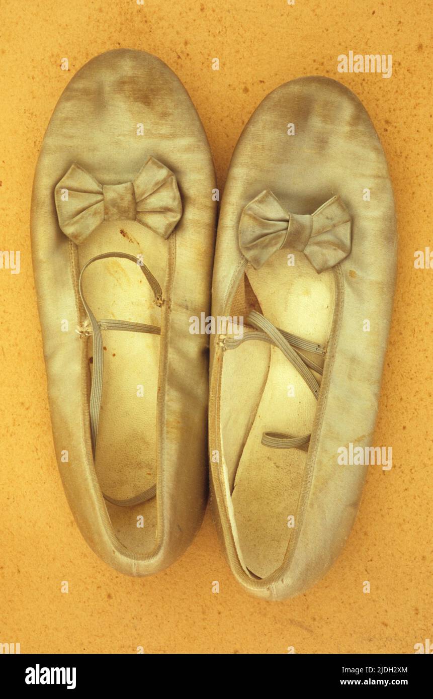 Pair of ballet or dancing shoes once white but now used and grubby ...