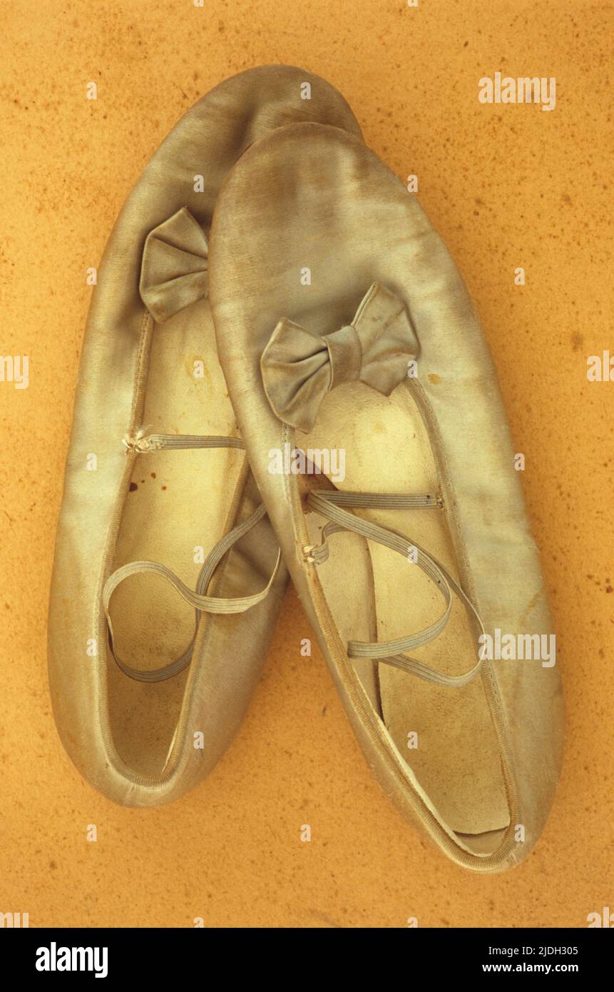 Pair of ballet or dancing shoes once white but now used and grubby ...