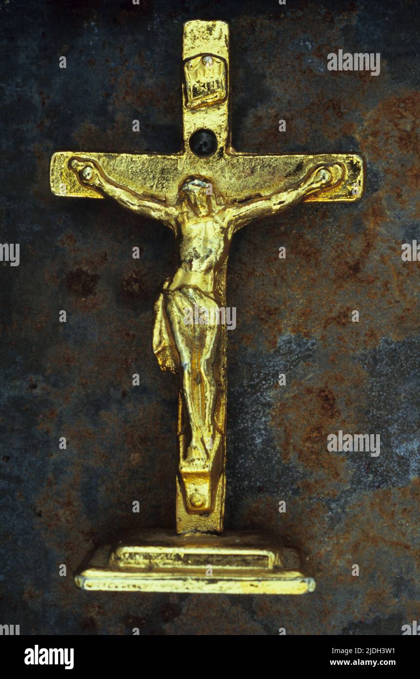 Free-standing small crucifix painted gold with figure of Jesus on it ...