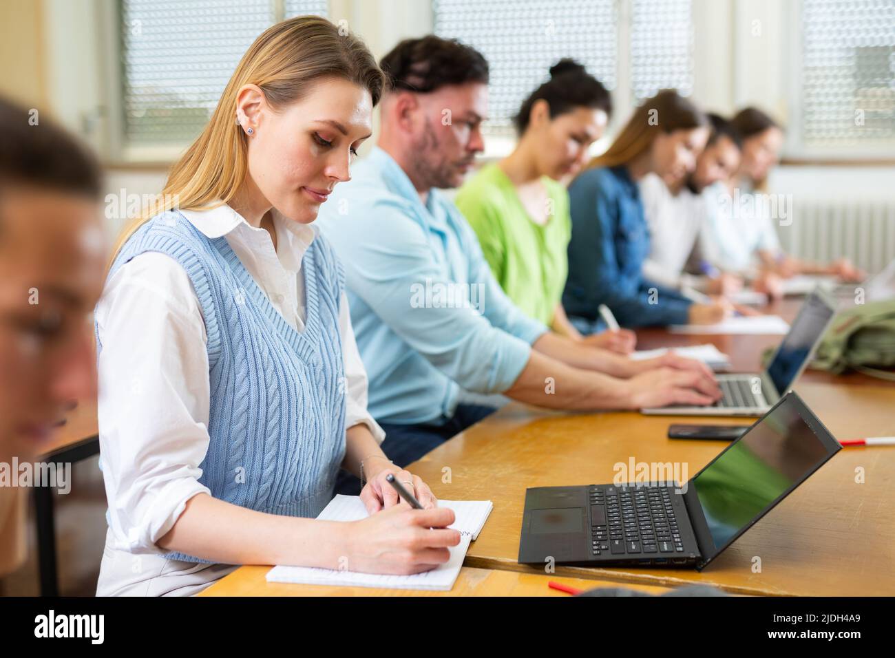 Woman university student writing in classroom Stock Photo - Alamy
