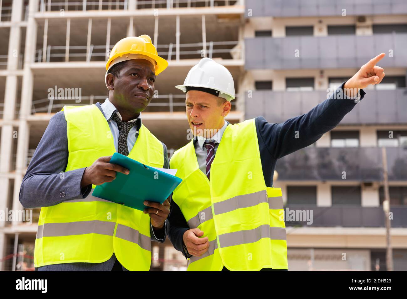 Two architect, civil engineer or building contractor colleagues on ...