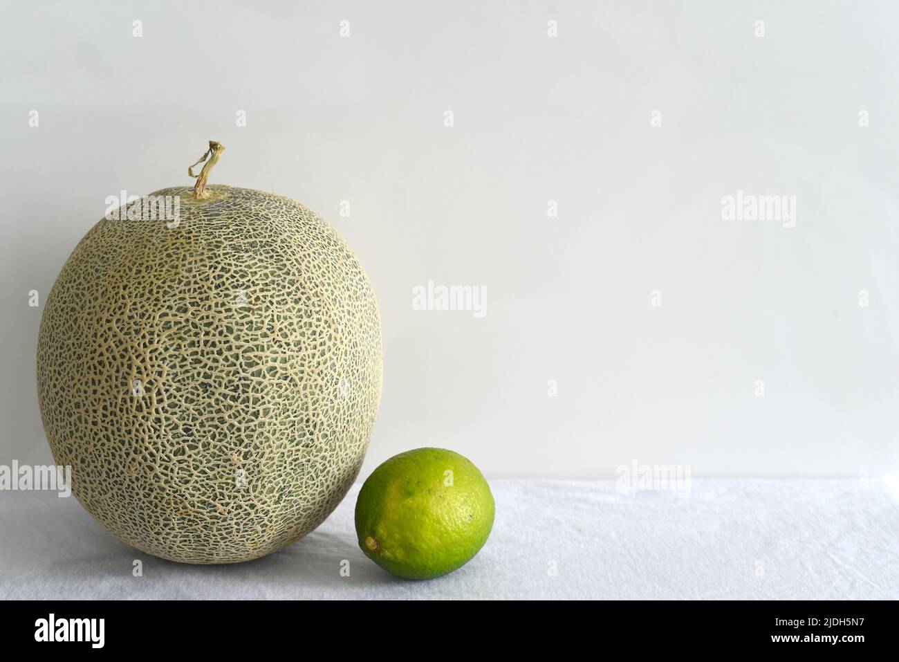 Melon and lime fruits on white background Stock Photo - Alamy