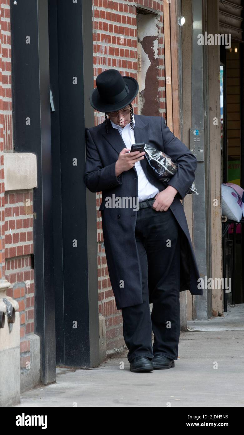 After morning services an orthodox Jewish man checks his cell phone for ...