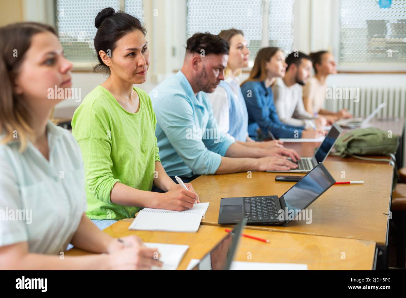 Woman university student writing in classroom Stock Photo - Alamy