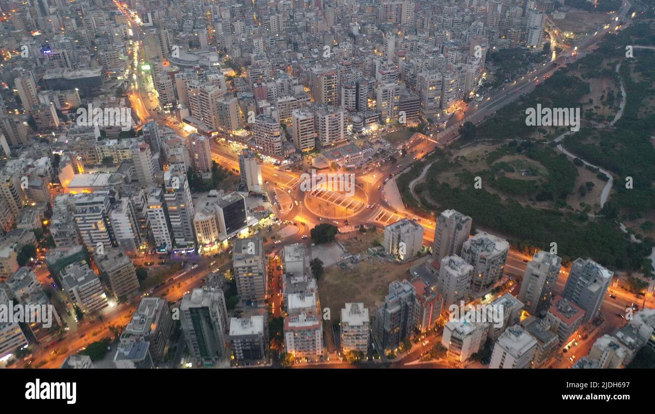 Top aerial night view of a traffic circle and urban park with yellow ...