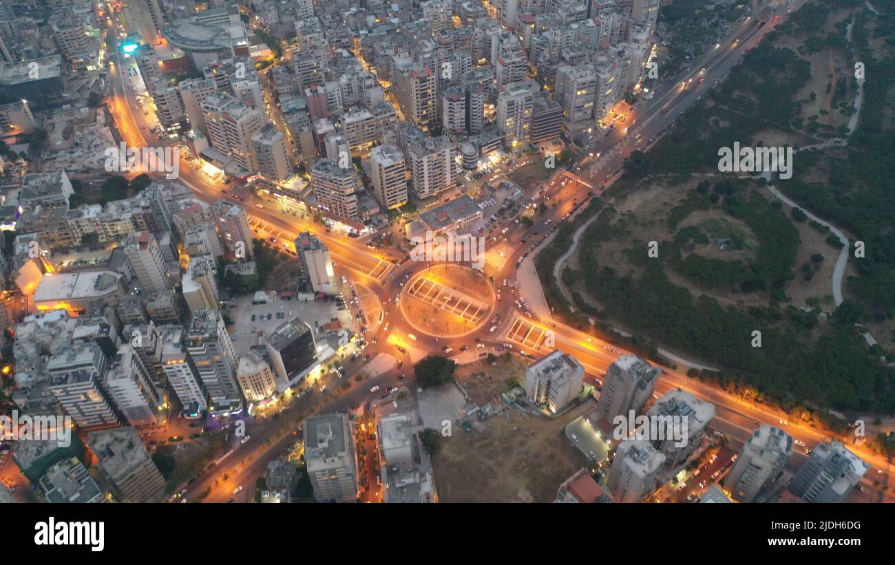 Top aerial night view of a traffic circle and urban park with yellow ...