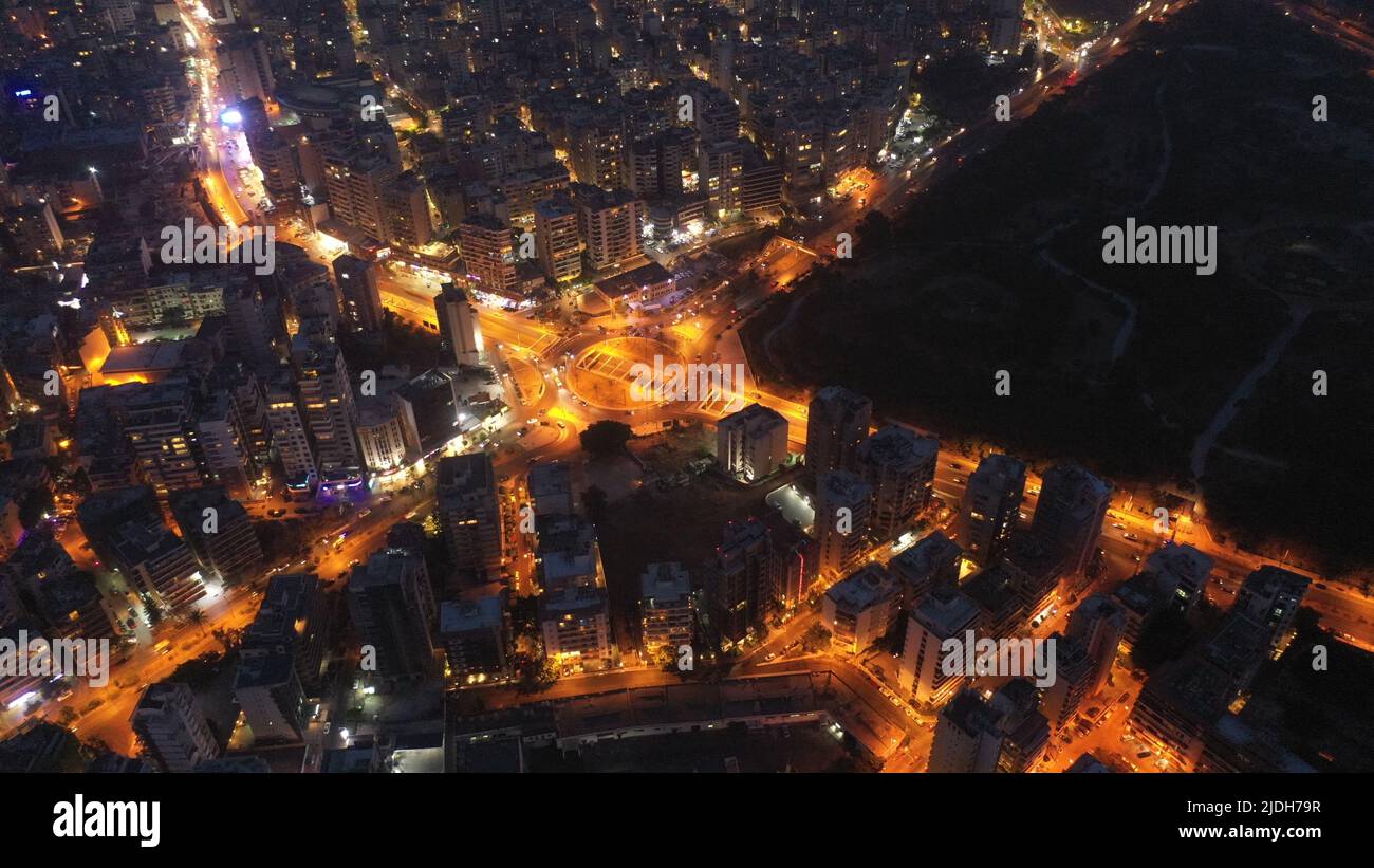 Top aerial night view of a traffic circle and urban park with yellow ...