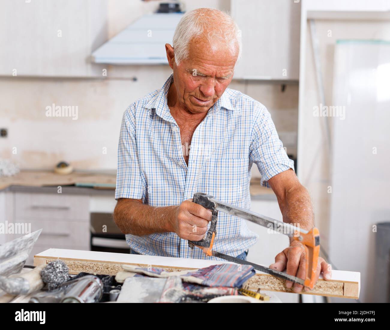 Man cutting wood board with hacksaw Stock Photo - Alamy