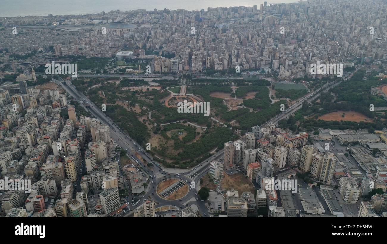 Top aerial view of a traffic circle and urban park with city skyline ...