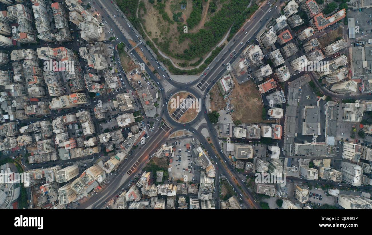 Top aerial view of a traffic circle and urban park with city skyline ...