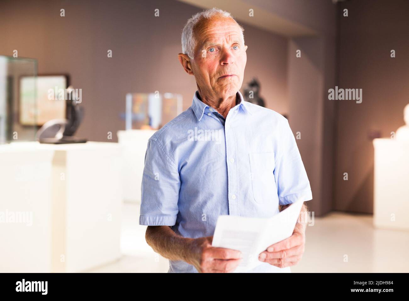 Man holding guide in museum Stock Photo - Alamy