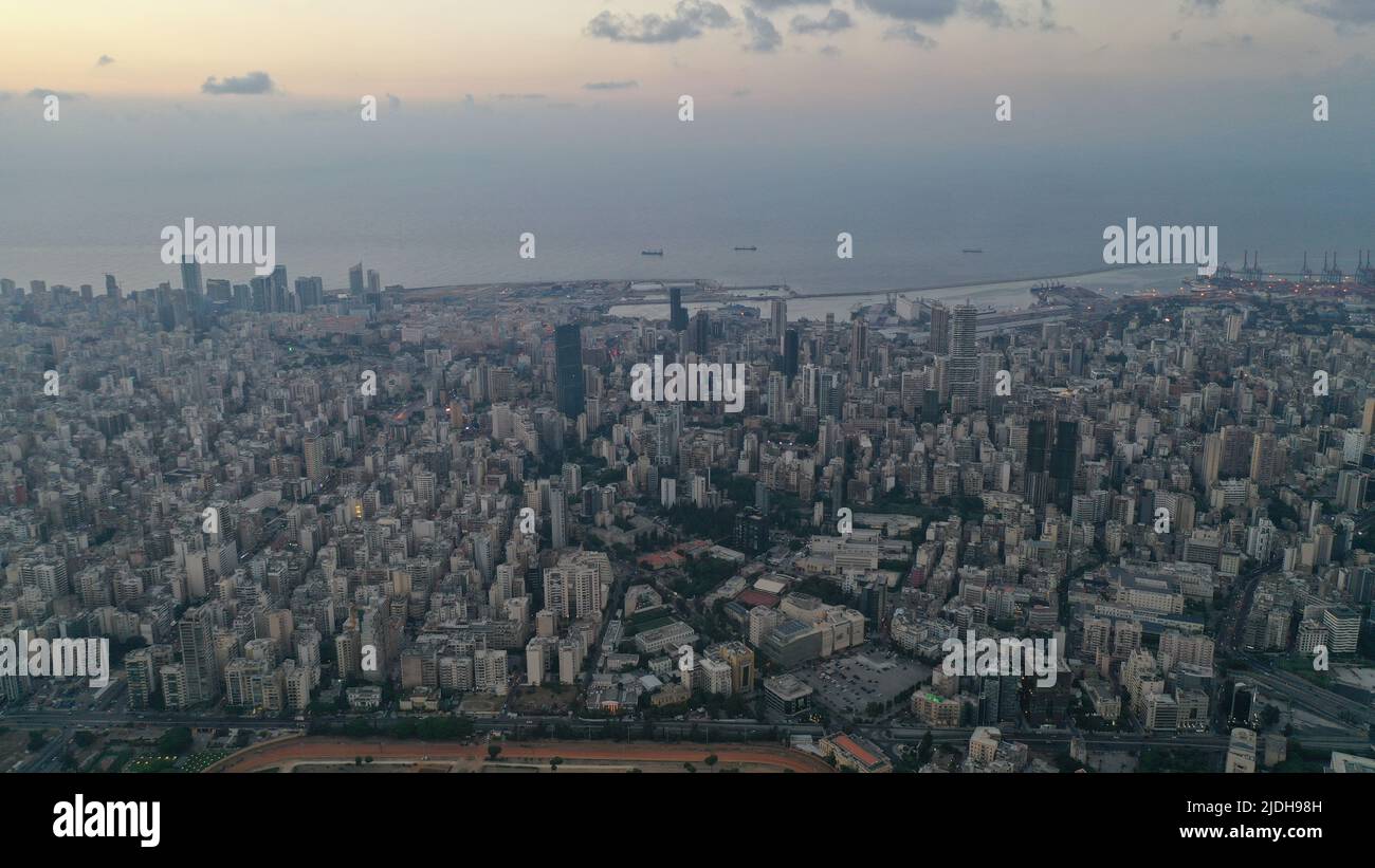 Top aerial view of a traffic circle and urban park with sea background ...