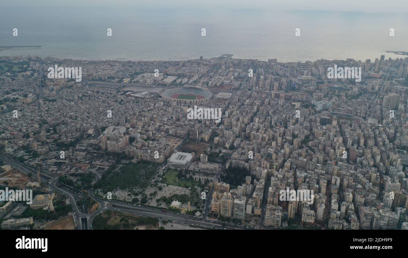 Top aerial view of a traffic circle and urban park with sea background ...