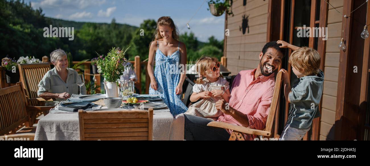 Three generation family having fun at barbecue party dinner on patio ...