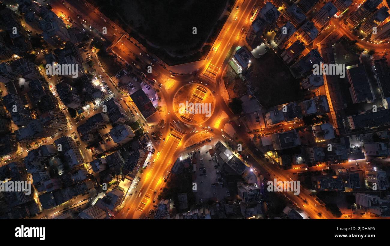 Top aerial night view of a traffic circle with yellow lights in ...