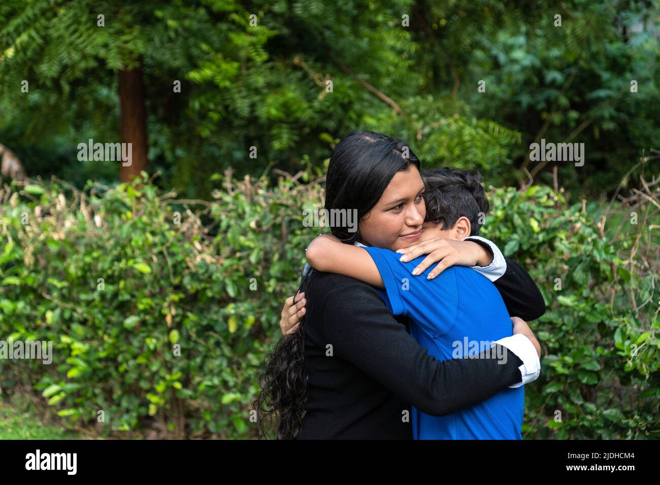 Two Latino brothers laughing and hugging each other in a park Stock ...