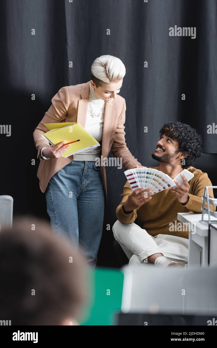advertising manager talking to indian designer sitting with mobile ...