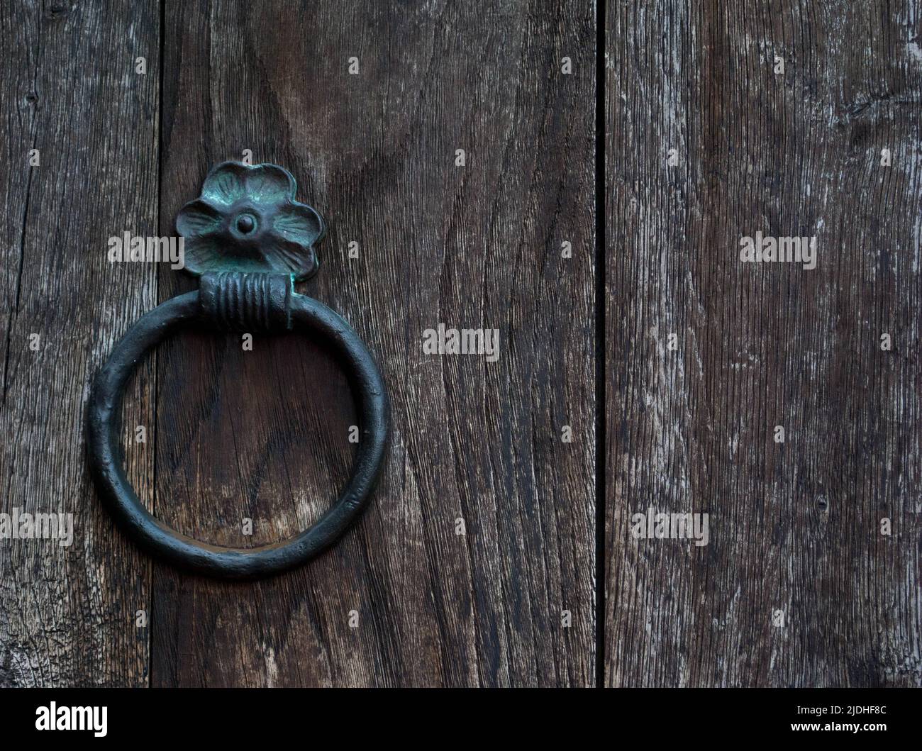 forged metal ring on a heavy wooden door, close-up textured background ...