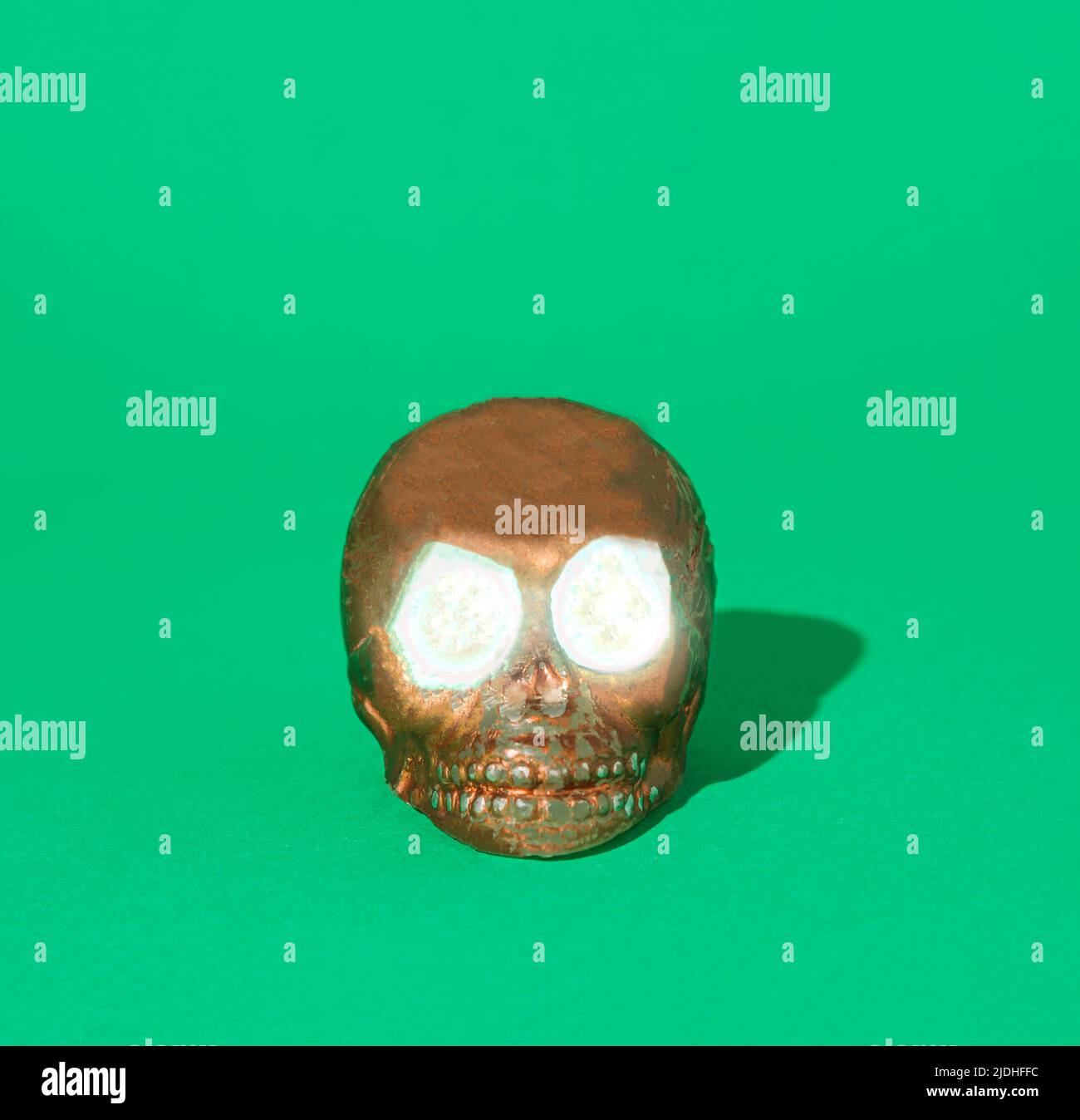Brown skull with neon light eyes on green background. Spooky Halloween ...