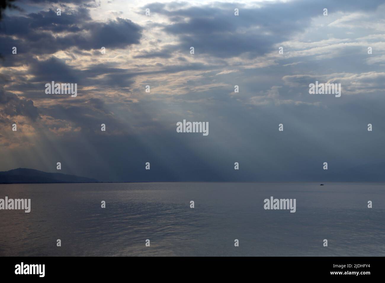 Shaft of sunlight through clouds hitting the sea in Greece Stock Photo ...