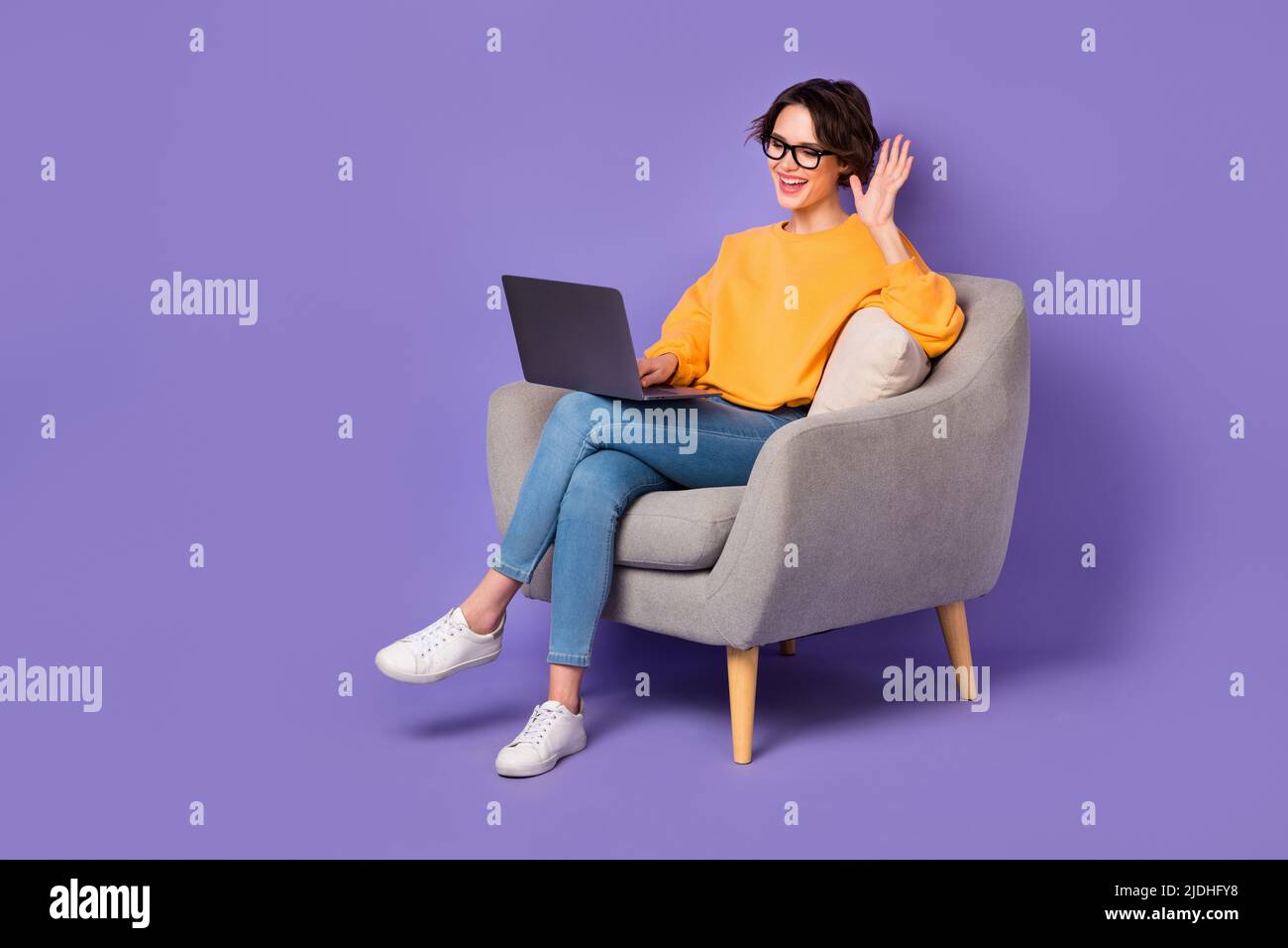 Portrait of attractive cheerful girl sitting using netbook calling on ...