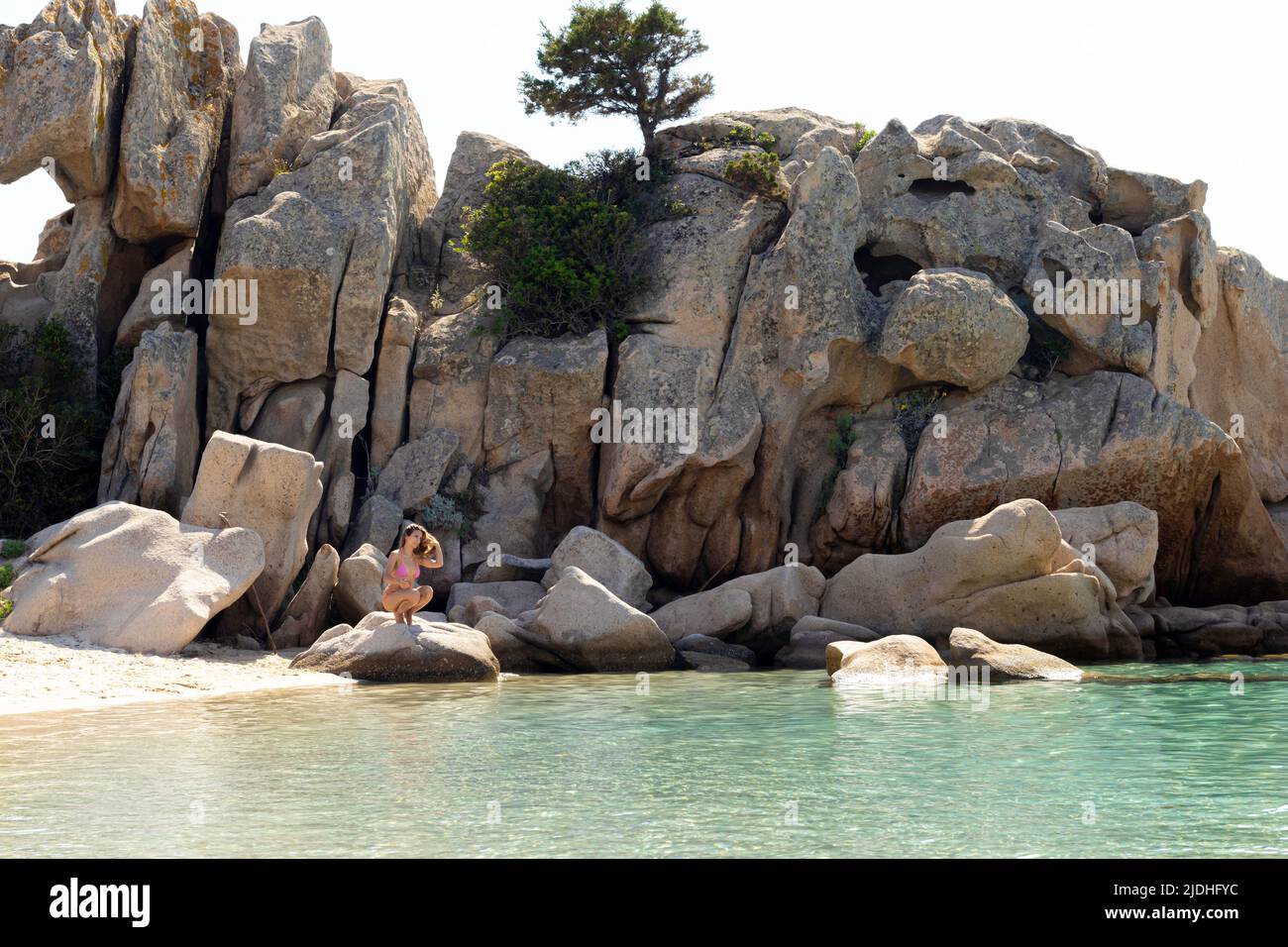 Young woman crouching on a rock hi-res stock photography and images - Alamy