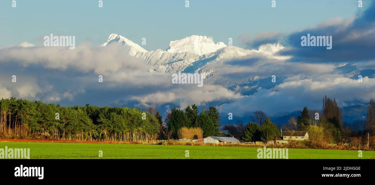 Pastoral overview over Fraser valley farm lands on snowy mountains ...