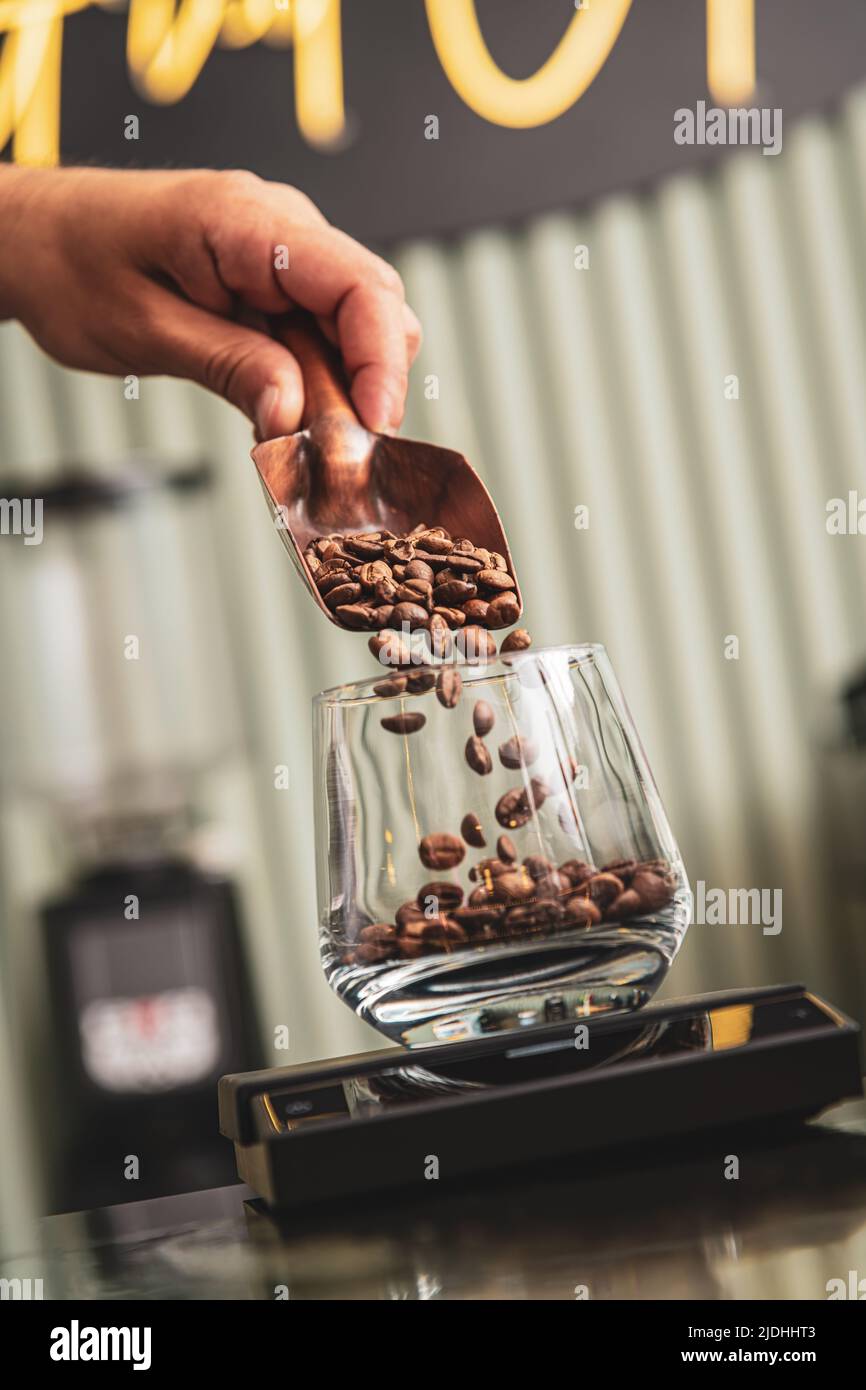 Barista weighing coffee beans to brew third generation coffee in coffee ...