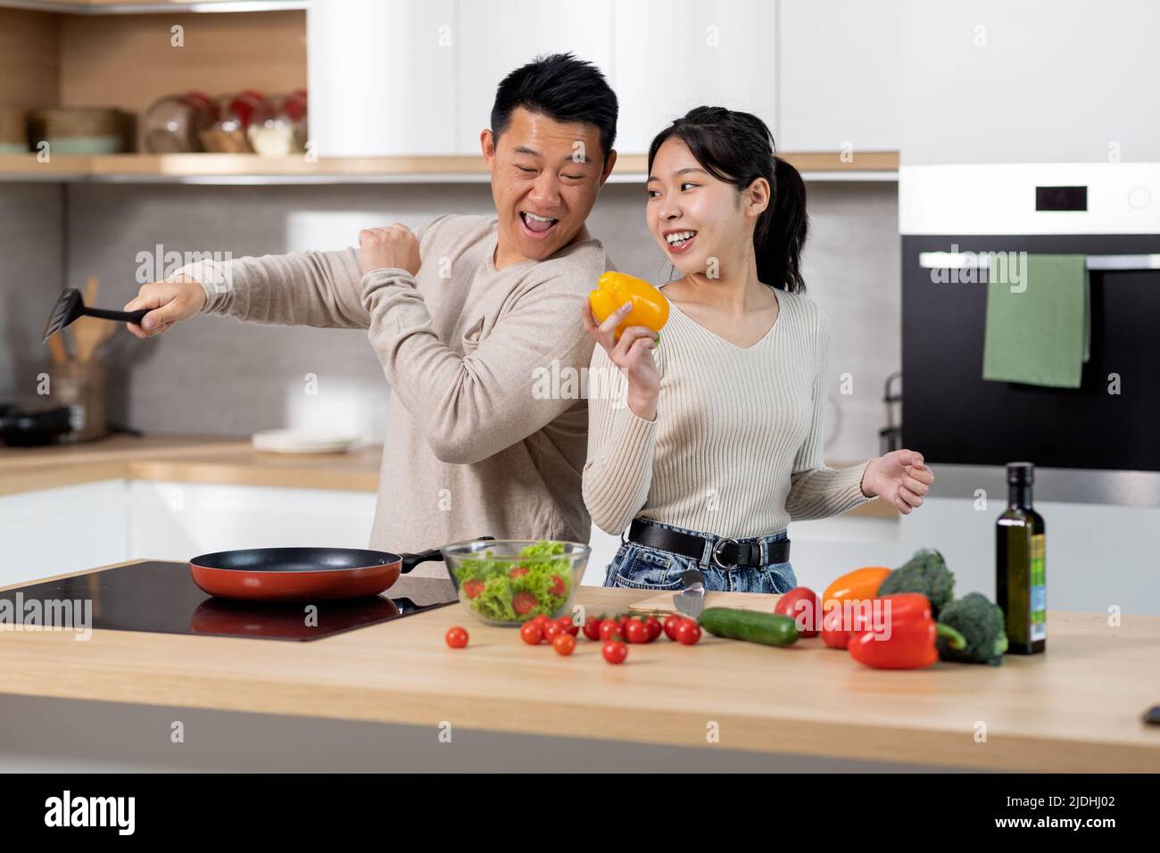 Happy asian man and woman cooking together at home Stock Photo - Alamy