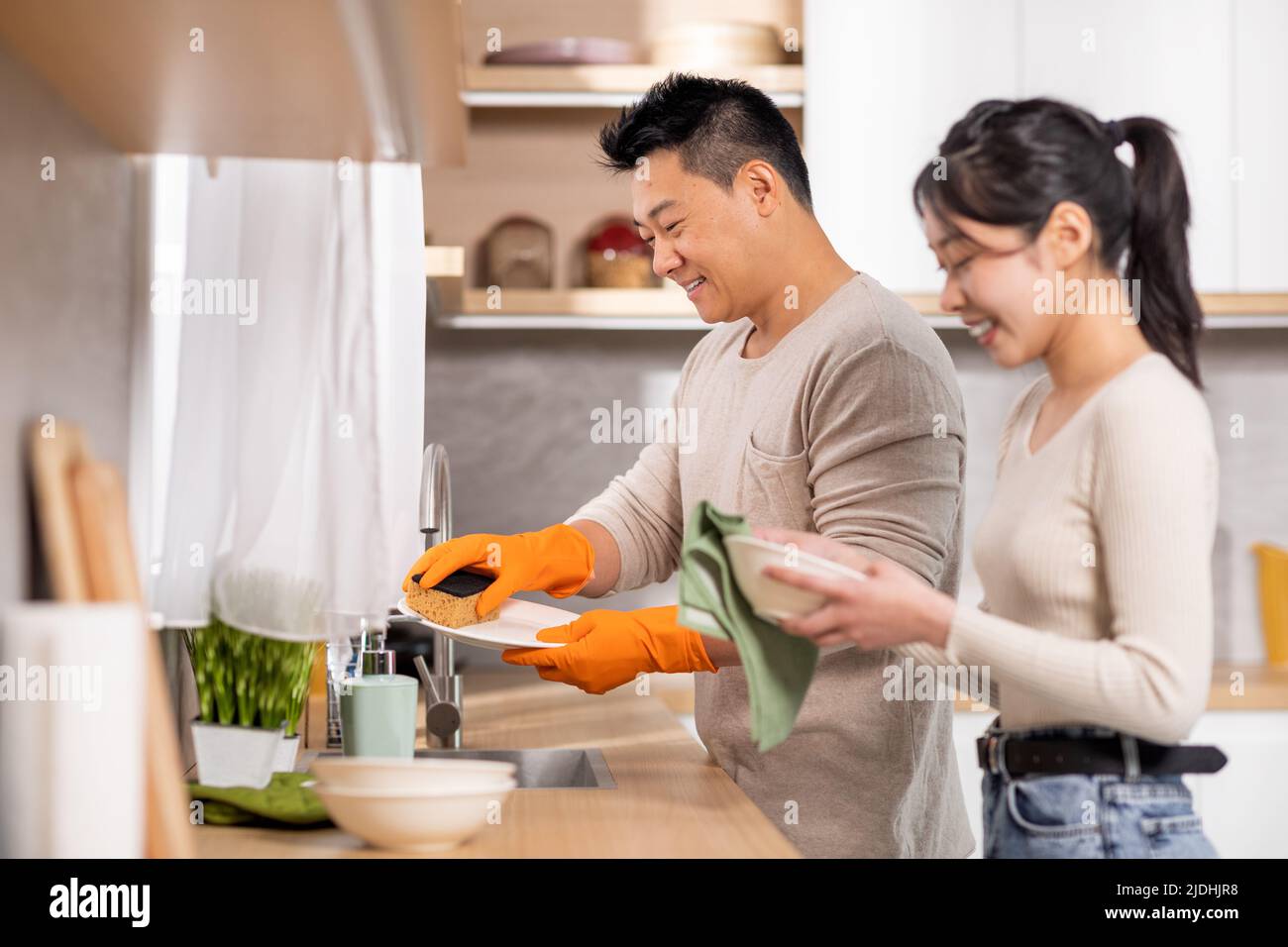 Loving asian couple washing dishes together at home Stock Photo - Alamy