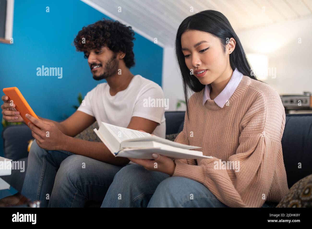 Two young people sitting on the sofa and studying Stock Photo - Alamy Two young people sitting on the sofa and studying Stock Photo - Alamy