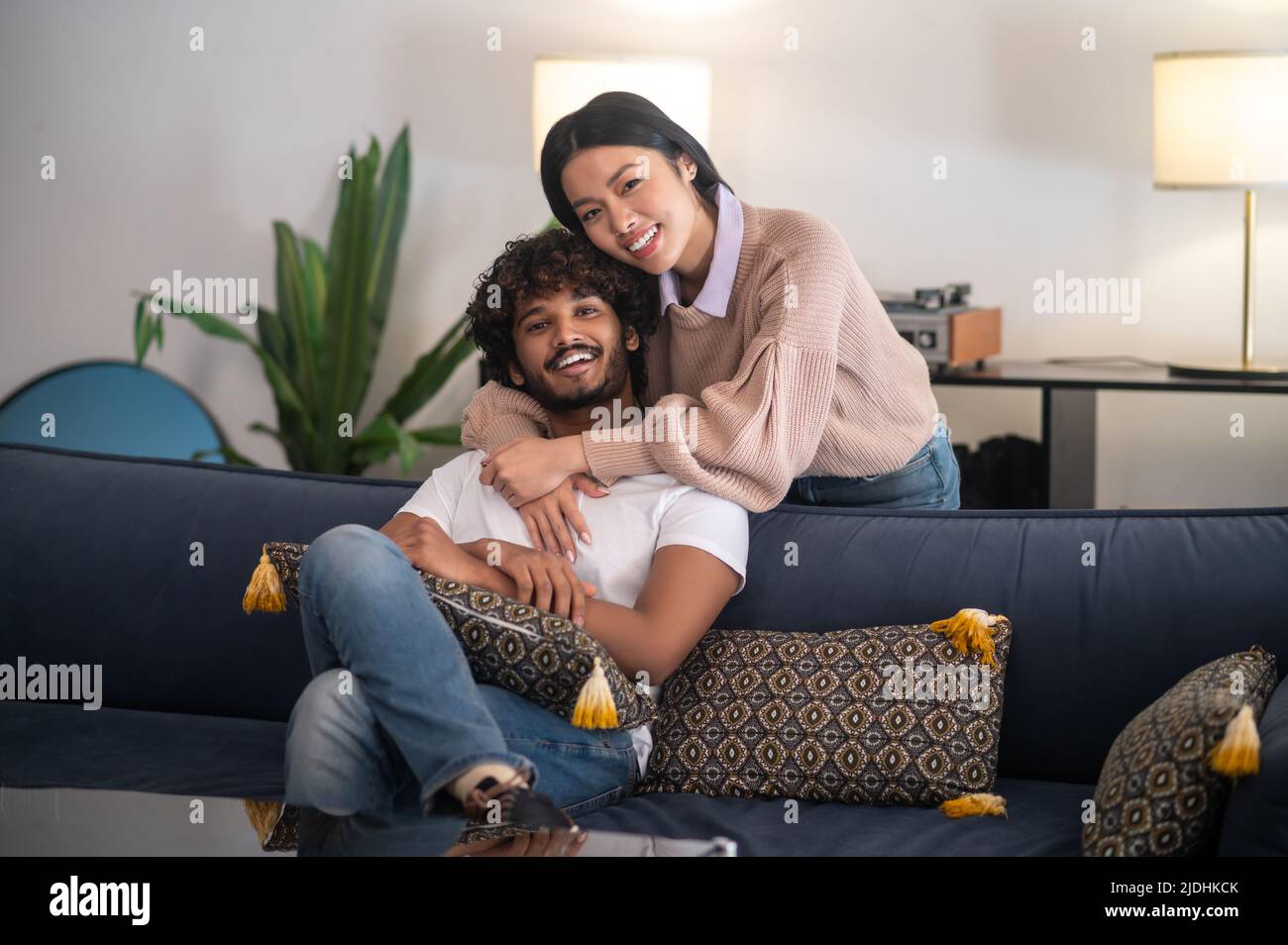 Two young people hugging and looking happy and cheerful Stock Photo - Alamy