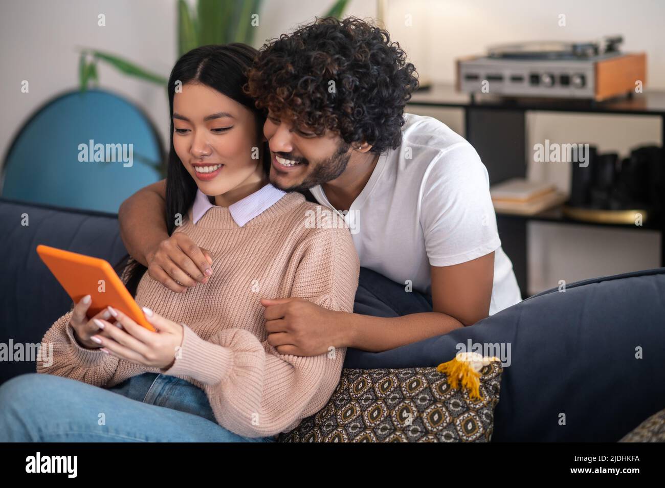 Young cute couple having a video call and looking involved Stock Photo ...