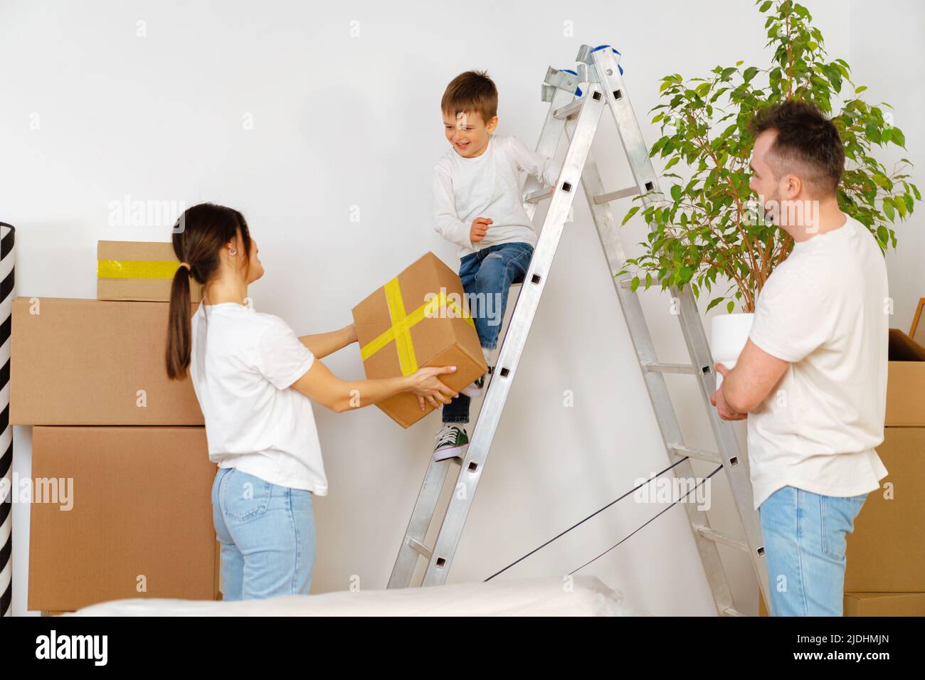 Portrait of happy family with cardboard boxes in new house at moving ...