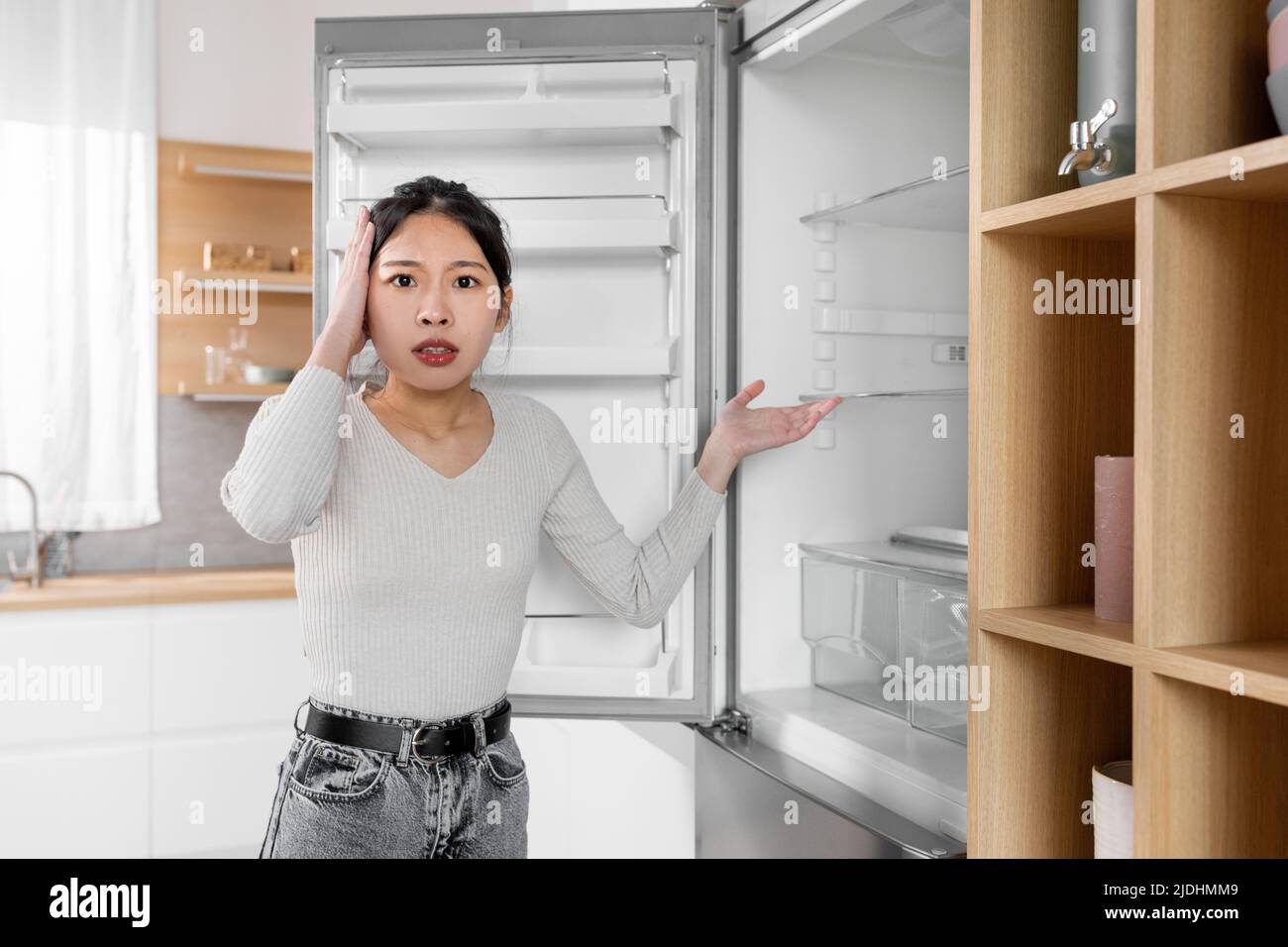 Shocked young korean lady standing by open empty fridge Stock Photo - Alamy